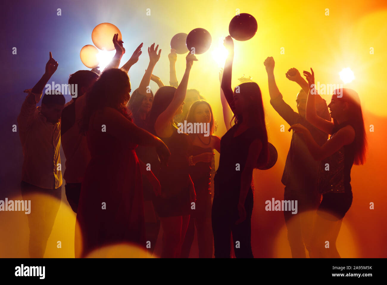 Happiness. A crowd of people in silhouette raises their hands on ...