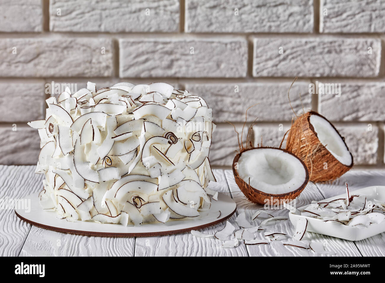 close-up of a coconut cake decorated with coconut ribbons with a brick ...