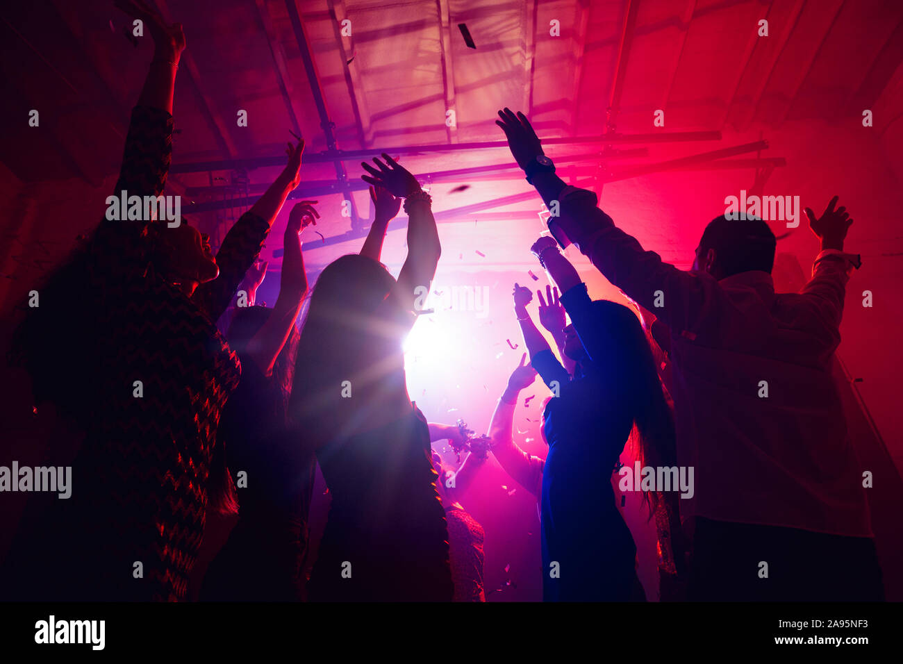 New Year's. A crowd of people in silhouette raises their hands on ...