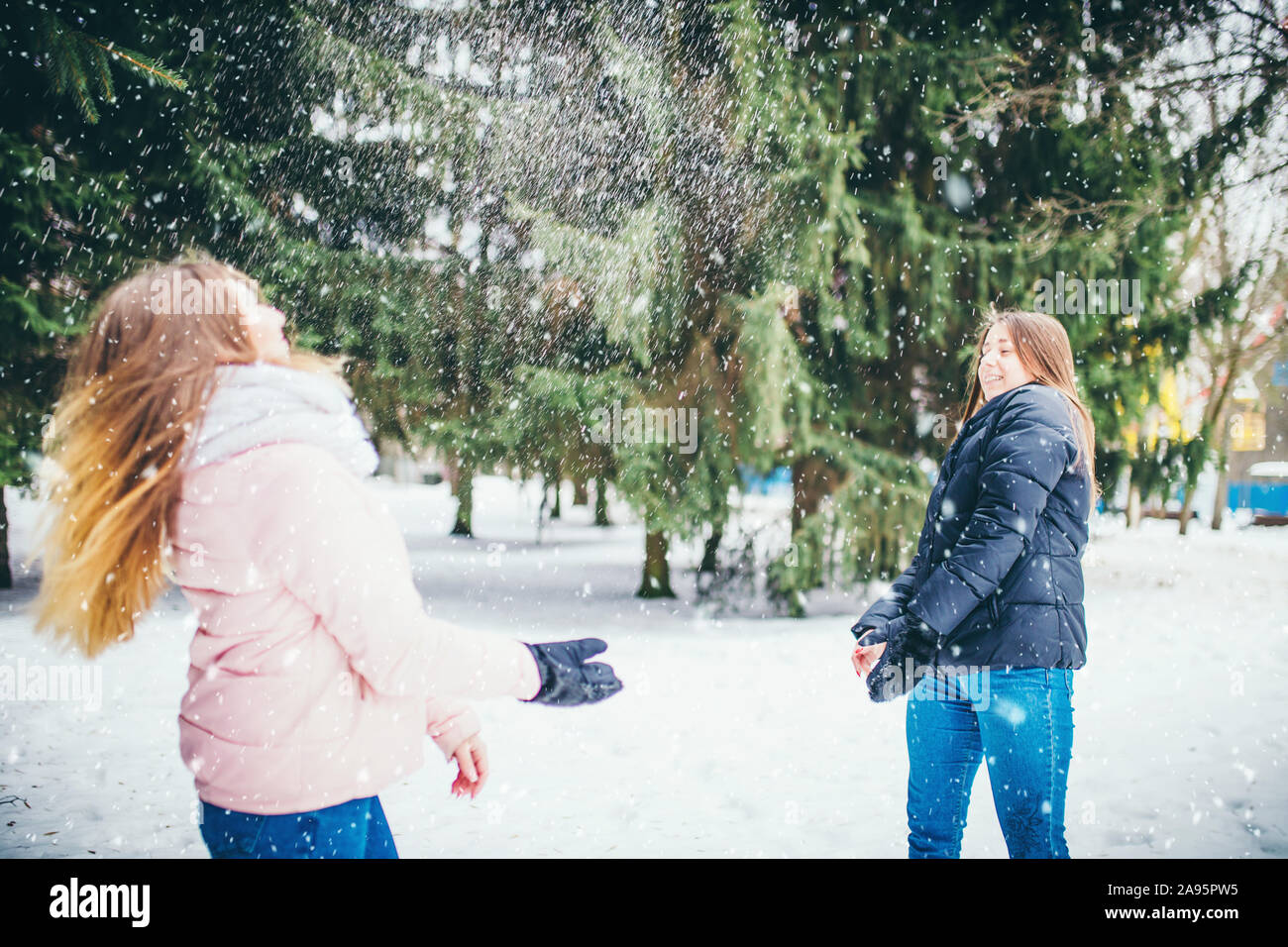 Farewell to childhood - two young girlfriends throw snowballs in the ...