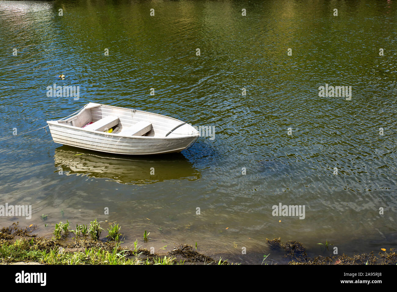 solitary fishing boat floating on the river Stock Photo - Alamy