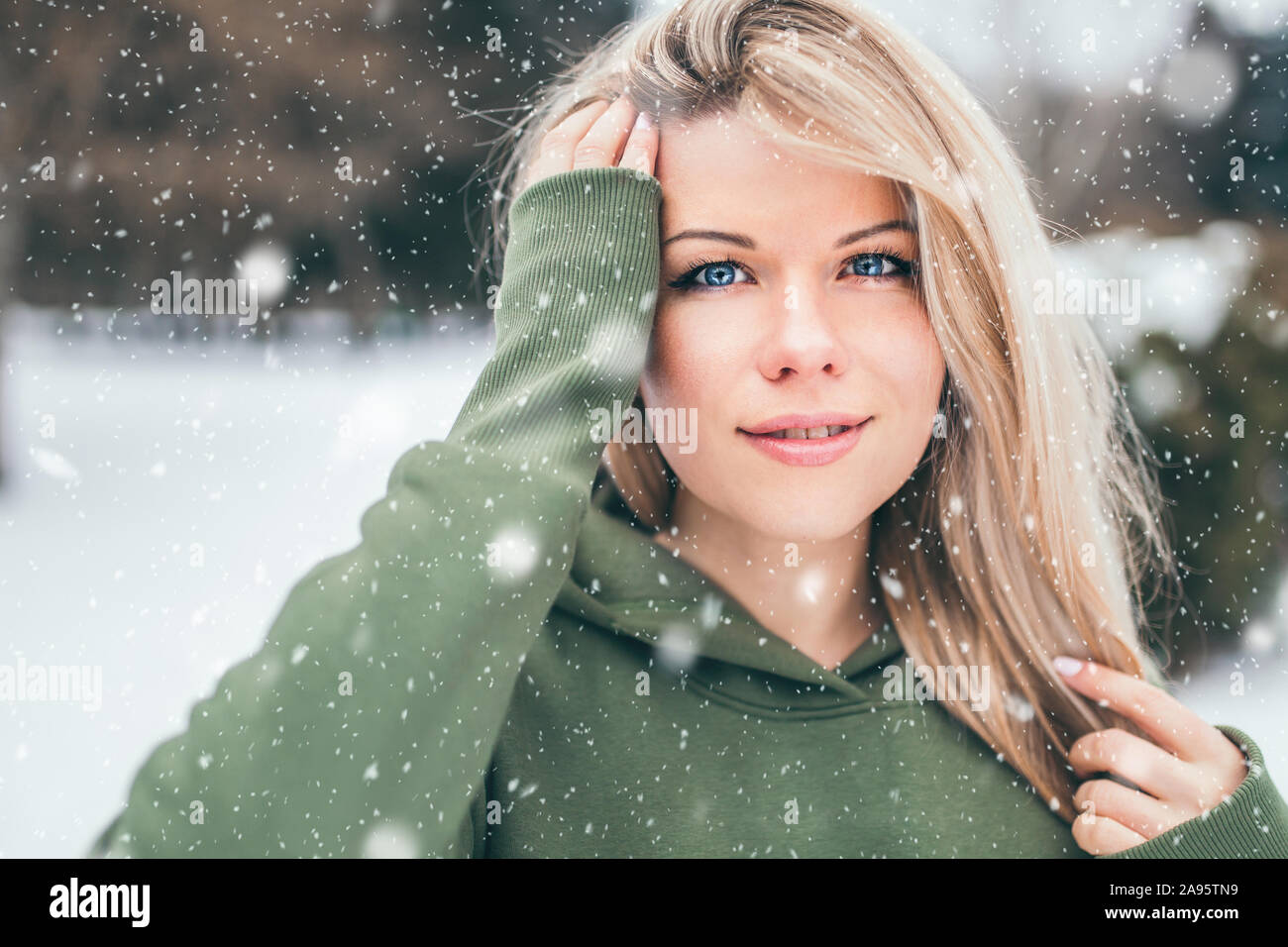Beautiful young woman with a dreamy facial expression straightens her ...