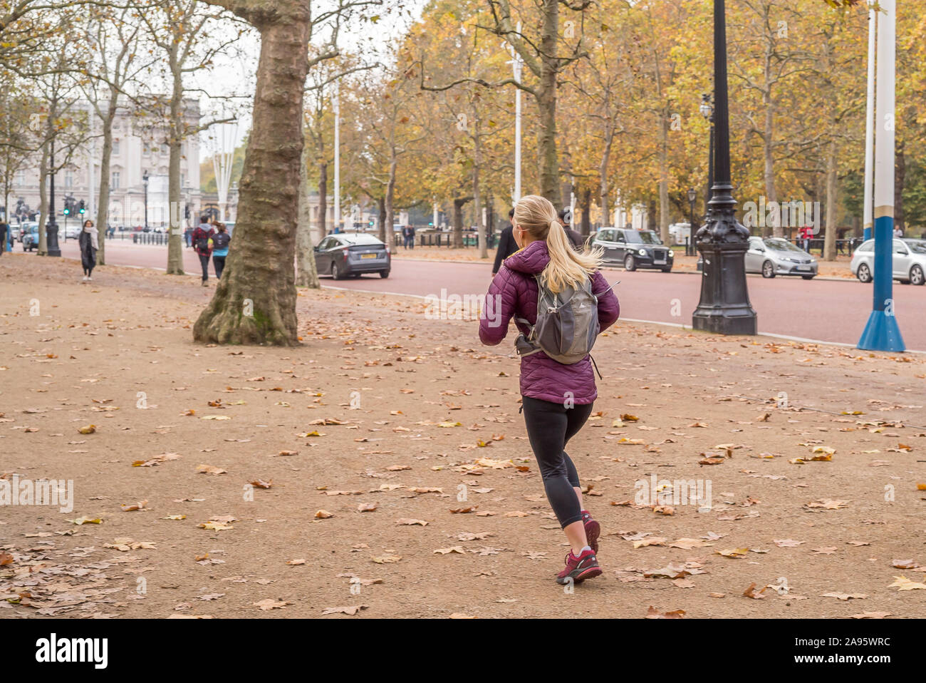 Female jogger, rear view, running on pavement of The Mall in central ...