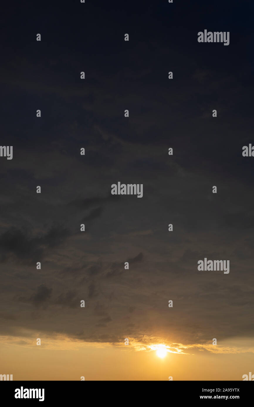 Sun rising under heavy dark clouds Stock Photo - Alamy