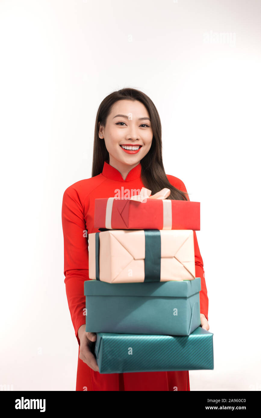 portrait of smiling young girl bring some gift boxes while wearing red ...