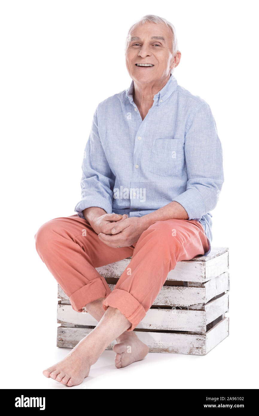 Elderly man sitting on the wooden box at white background Stock Photo ...
