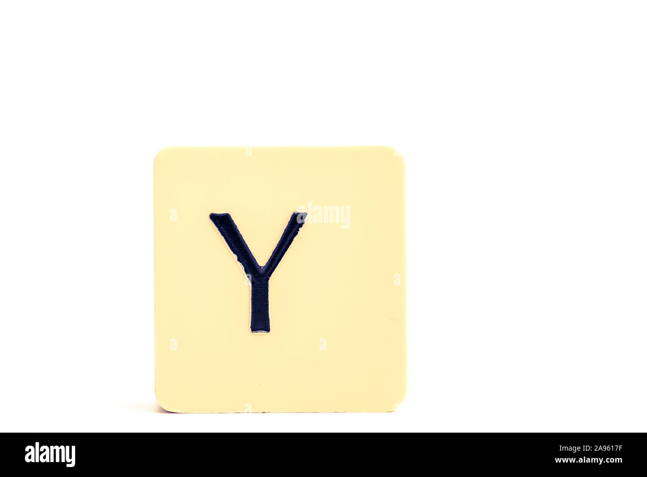 Dark letter Y on a pale yellow square block isolated on white ...