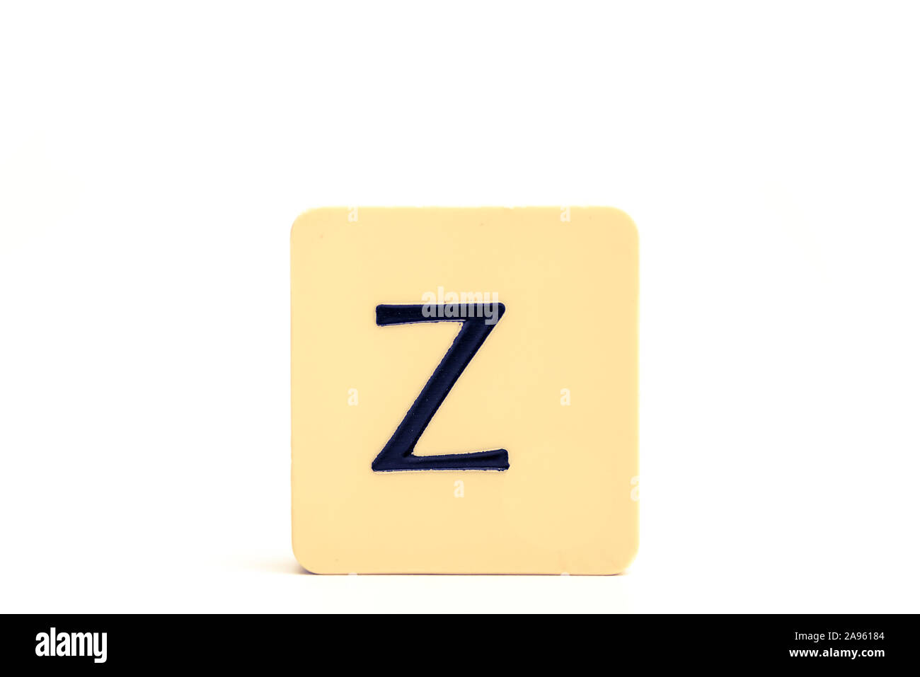 Dark letter Z on a pale yellow square block isolated on white ...