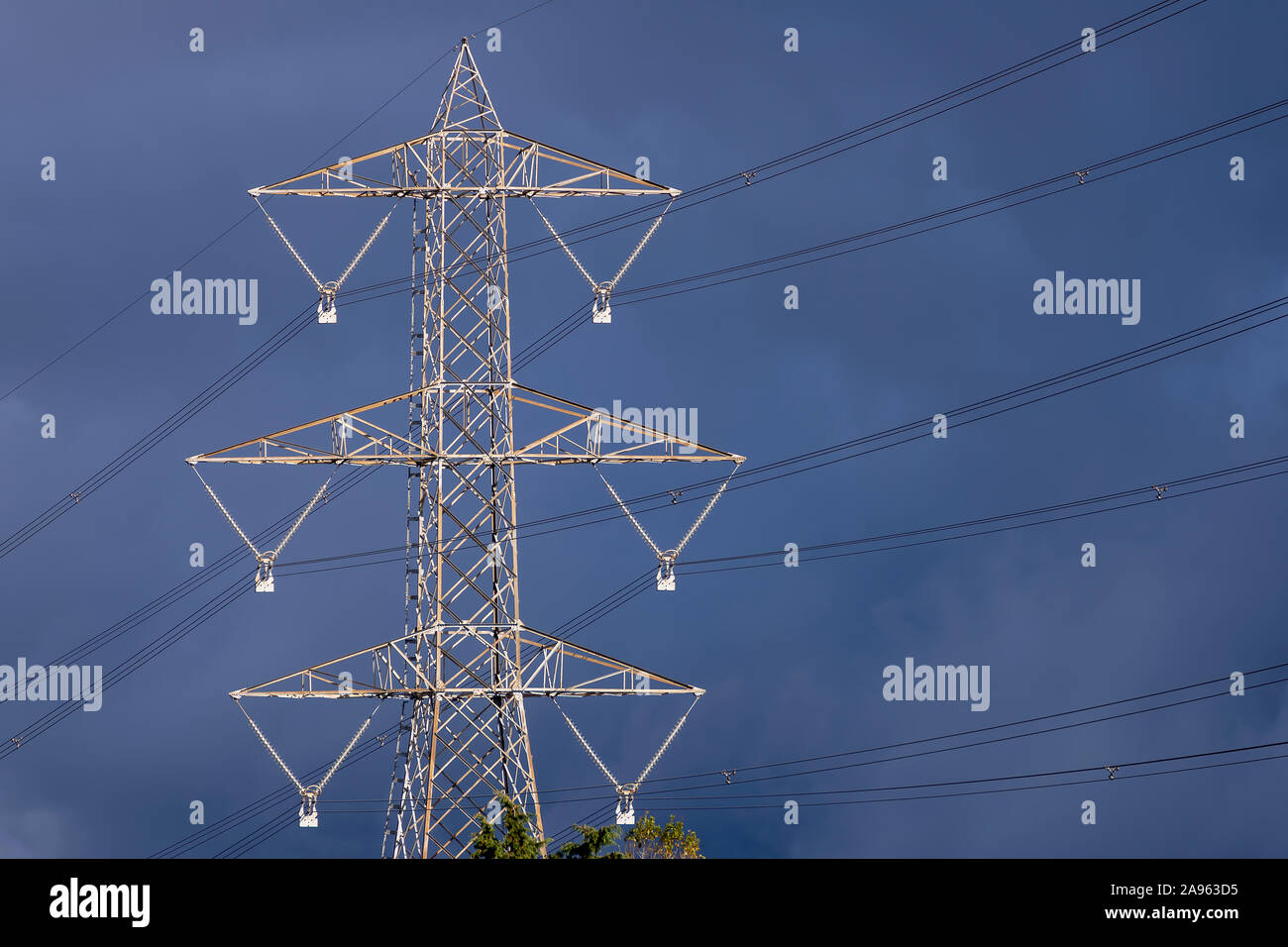 High voltage pylon isolated against a dark and stormy sky Stock Photo ...