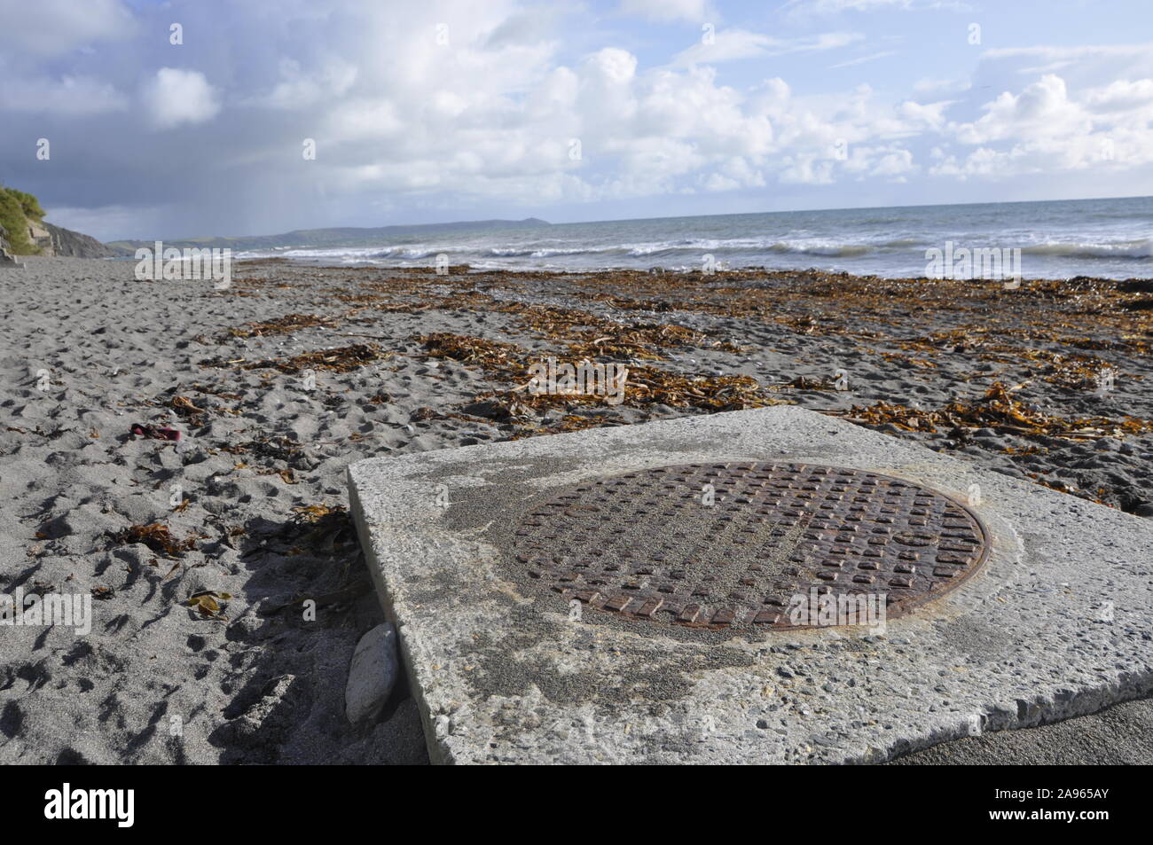 manhole cover on beach with blue sky Stock Photo - Alamy