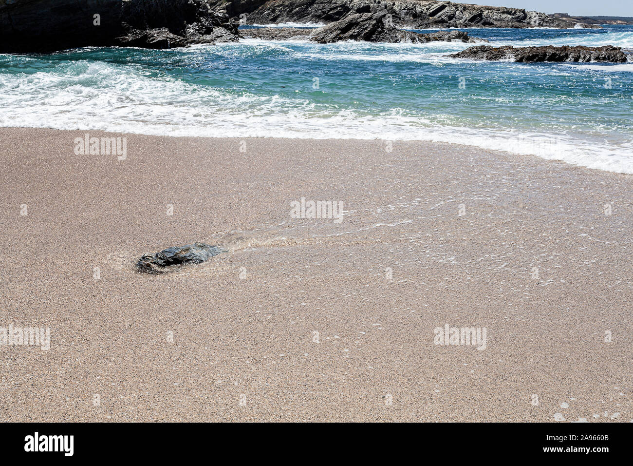 Waves at the beach. Secluded stone in beach sand in waves surf zone ...