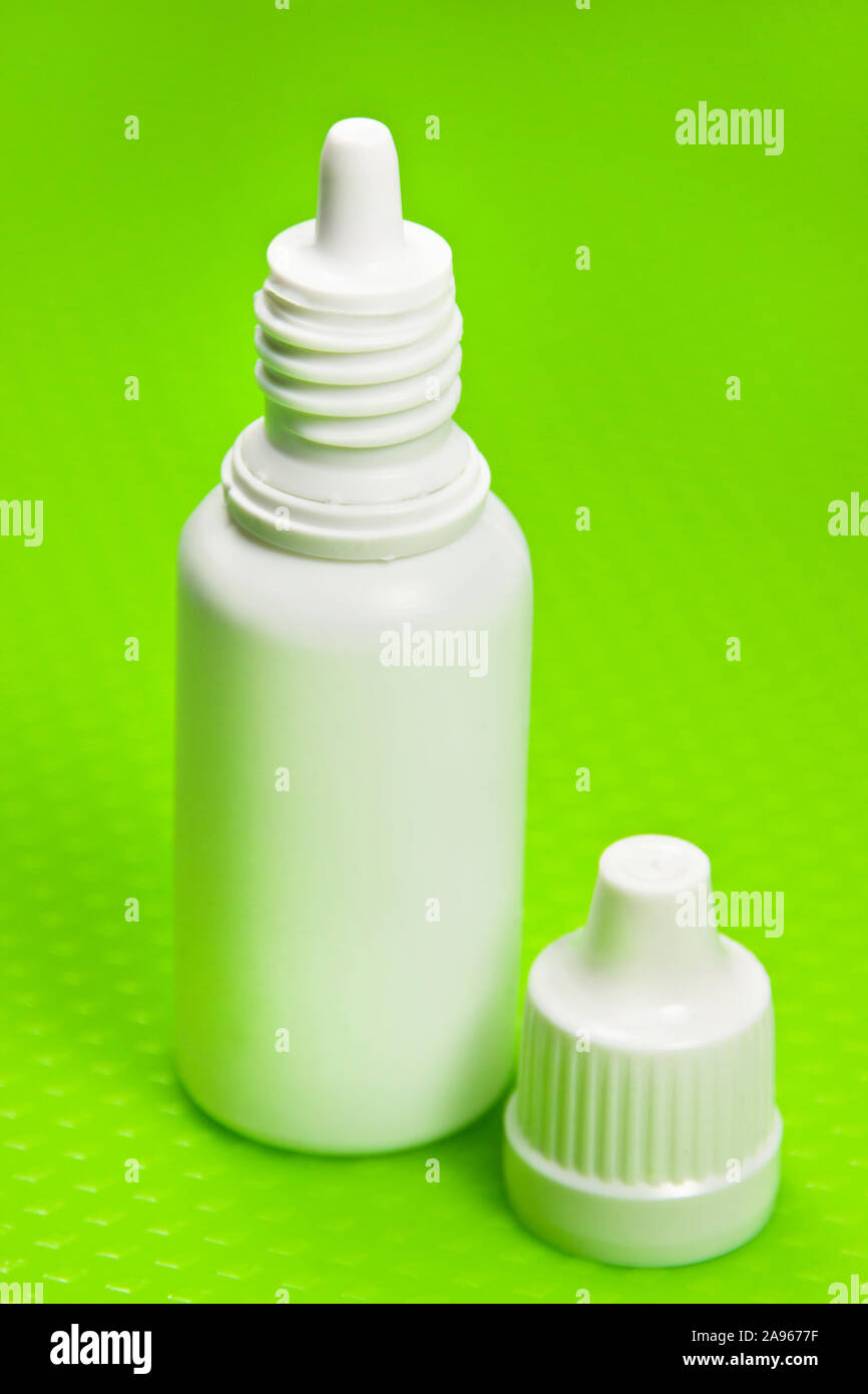 Medical eye drops and green background Stock Photo - Alamy