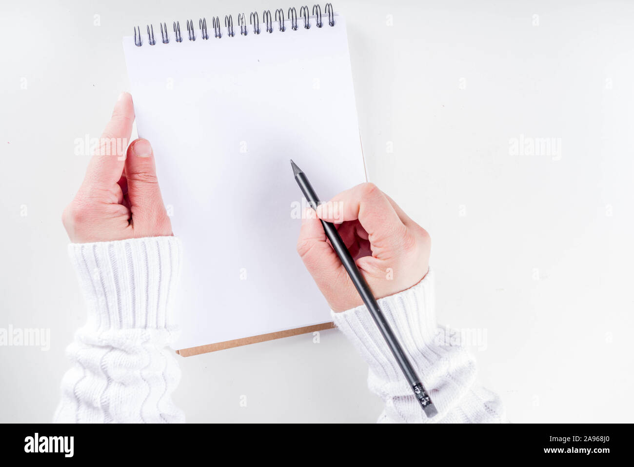 Woman hands ready to write or draw something in notepad top view ...