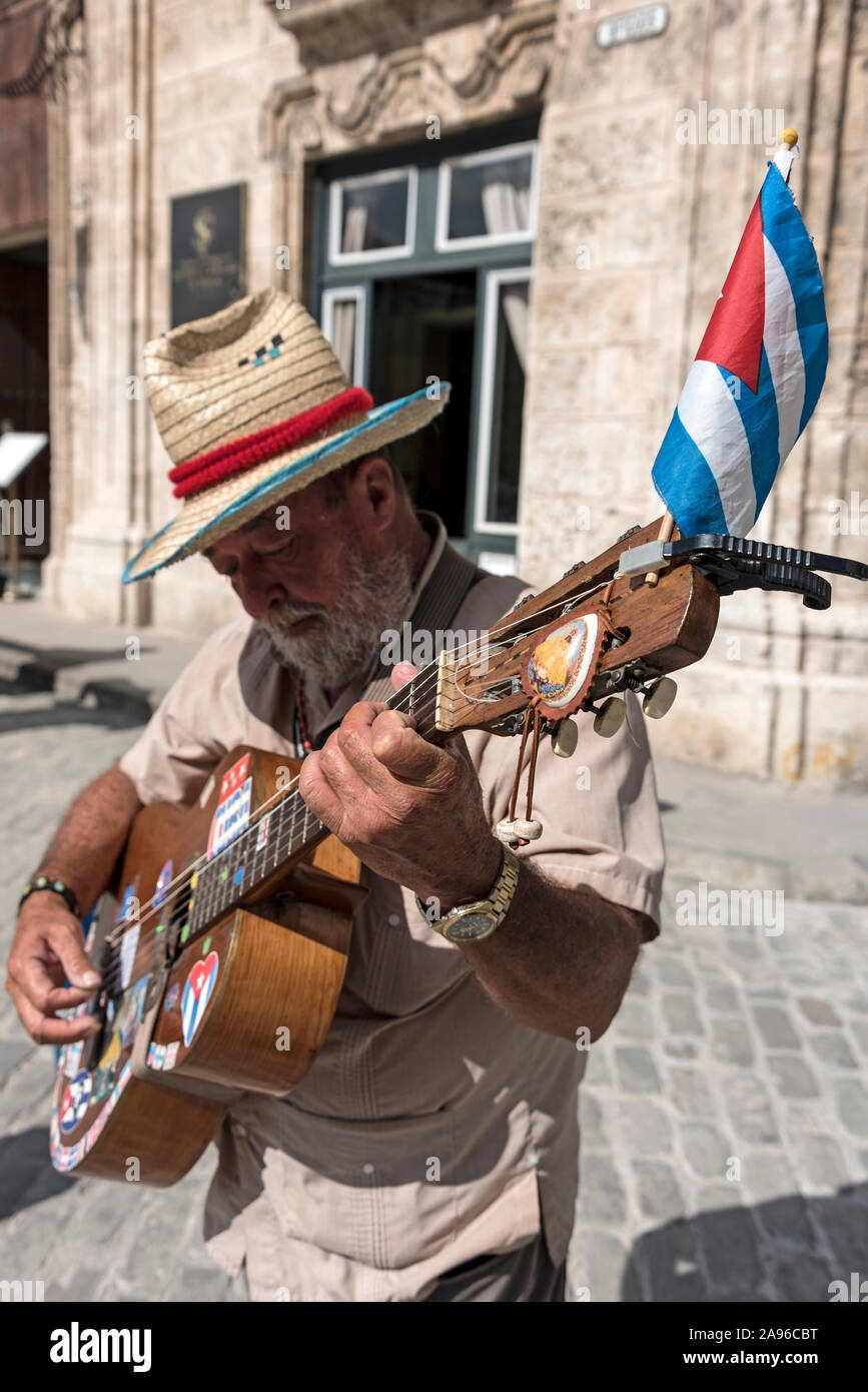 A Cuban street musician playing his guitar to tourists in Plaza San ...
