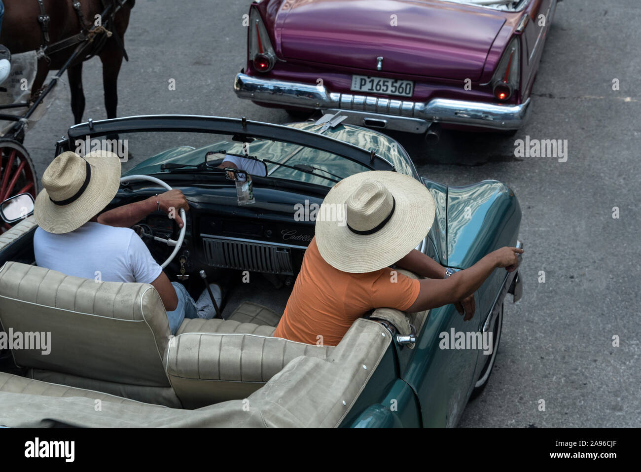A driver and his colleague wearing traditional Cuban wide brim hats ...