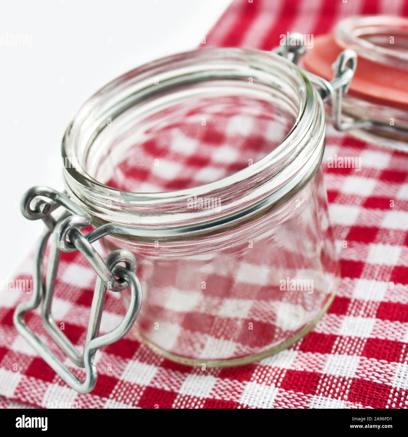 Preserving jar and checked towel on white background Stock Photo - Alamy