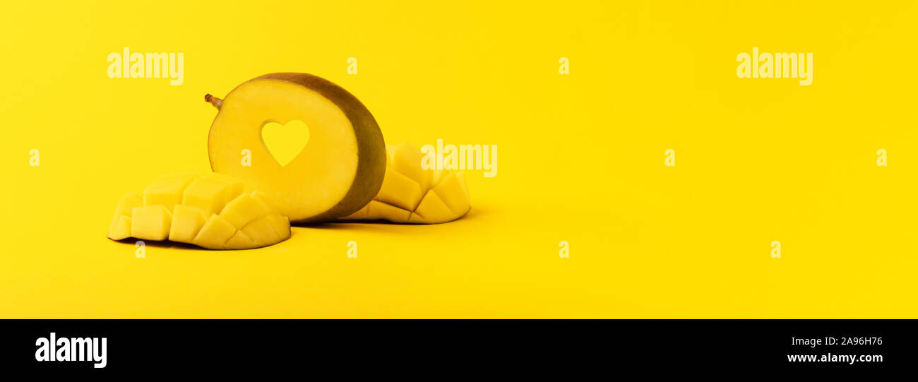 mango fruit with sliced mango heart on yellow background, panoramic ...