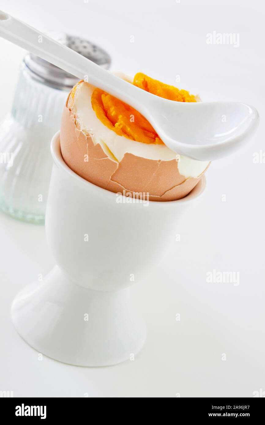 Boiled egg and egg cup with spoon Stock Photo - Alamy