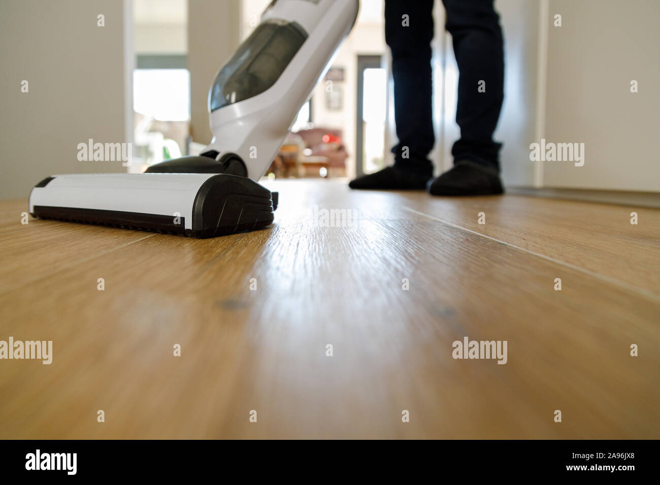 Man running the vacuum cleaner on the floor Stock Photo - Alamy