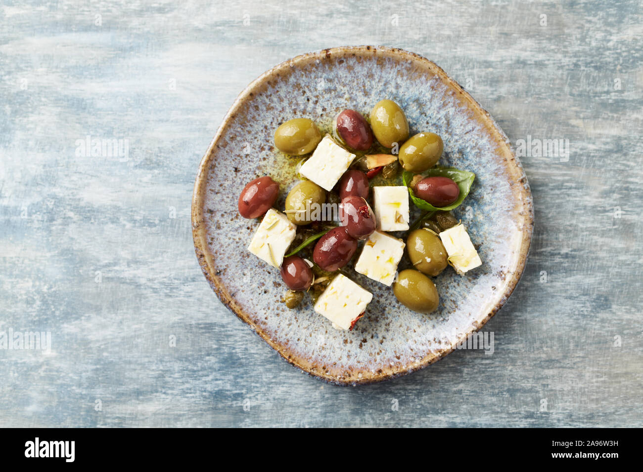 Green and kalamata olives, capers and feta cheese on rustic wooden ...
