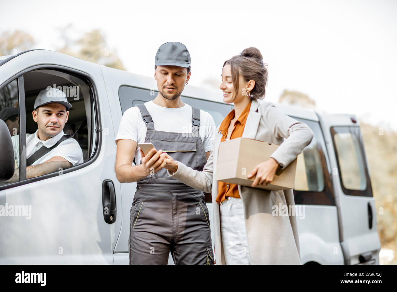 Delivery company employees in uniform delivering goods to a client by ...