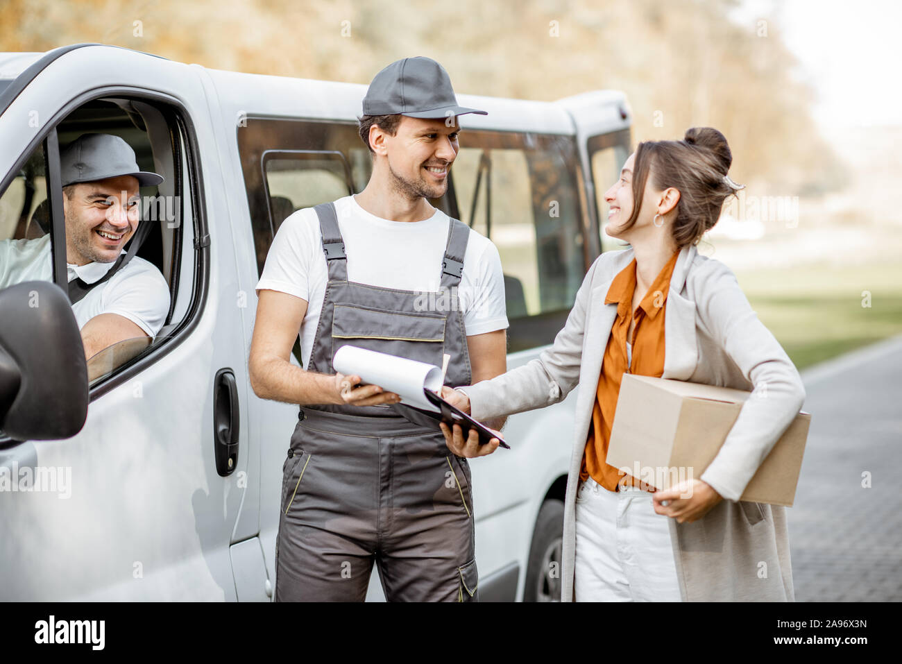 Delivery company employees in uniform delivering goods to a client by ...