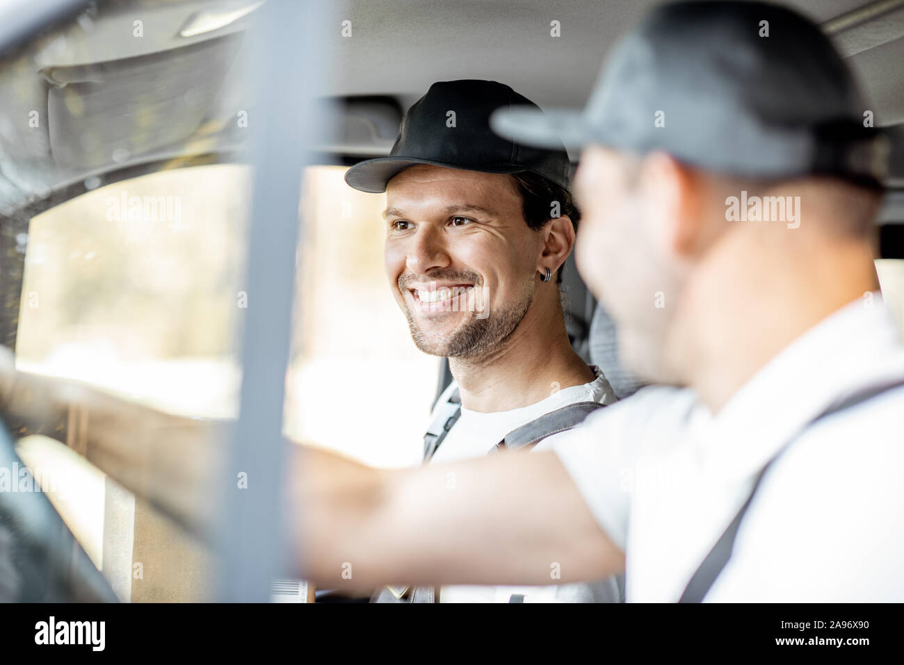 Two cheerful delivery company employees in uniform having fun while ...