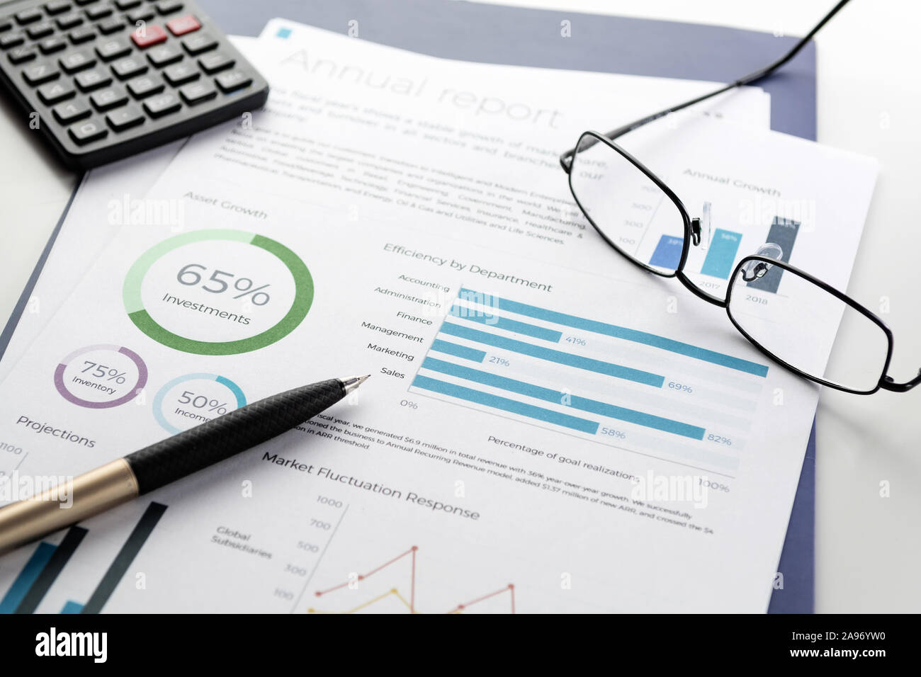 Mockup financial charts report sheet with visible pen, calculator and ...