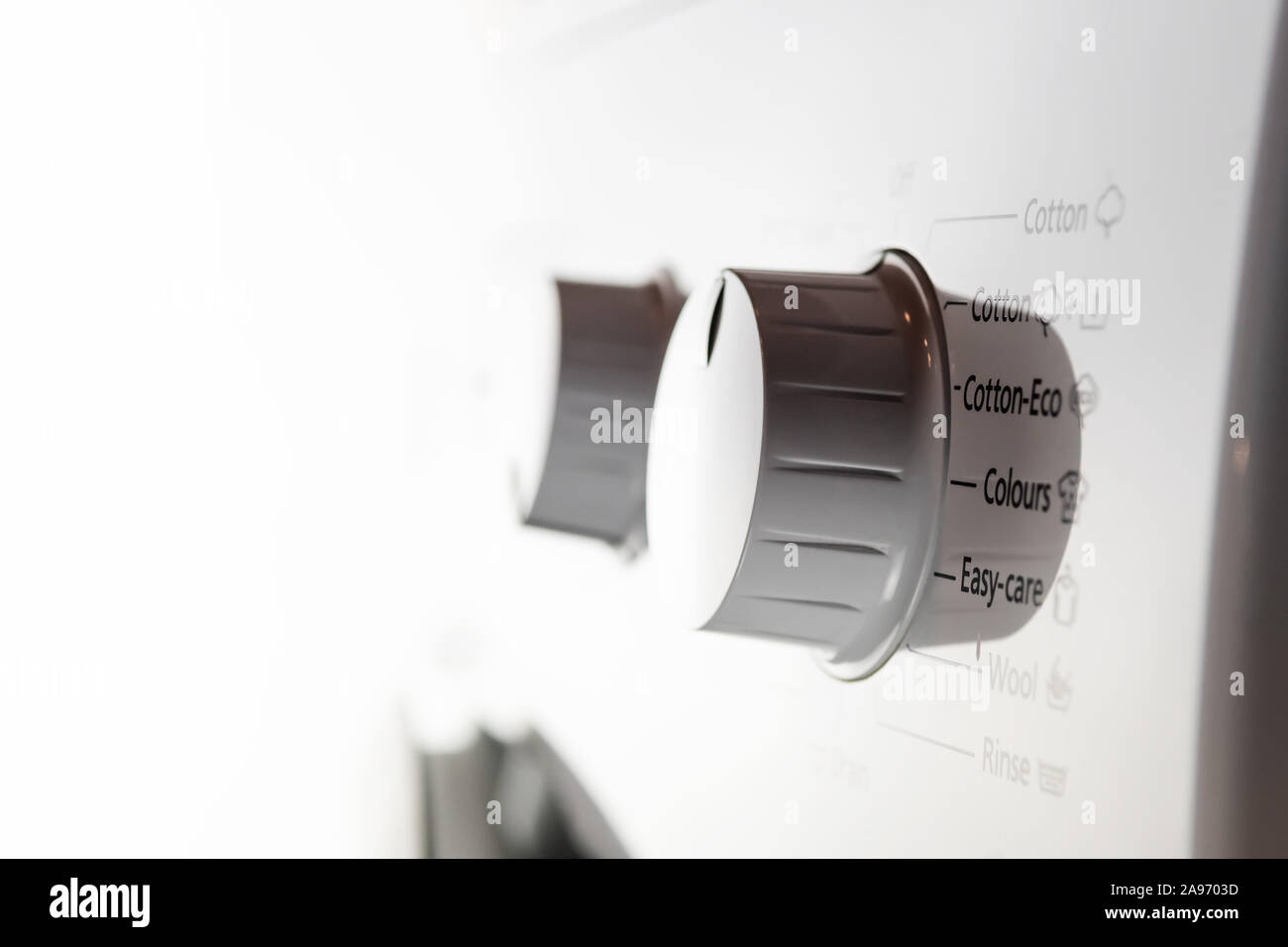Closeup of white modern washing machine control panel dials and buttons ...