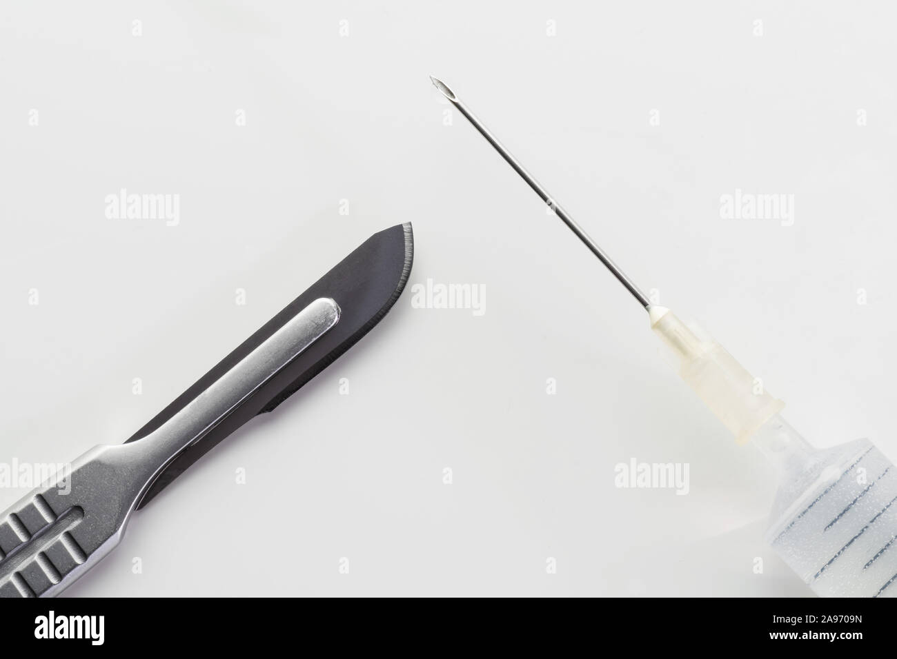 Surgical scalpel and medical syringe isolated on white background ...