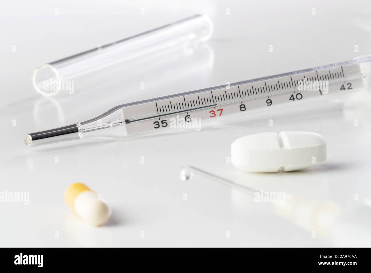 Medical mercury thermometer, pills, vaccine in medical syringe and ...