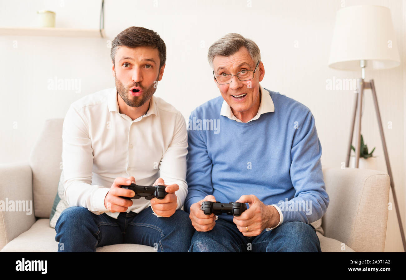 Mature Son And Elderly Father Playing Video Game Having Fun Together ...
