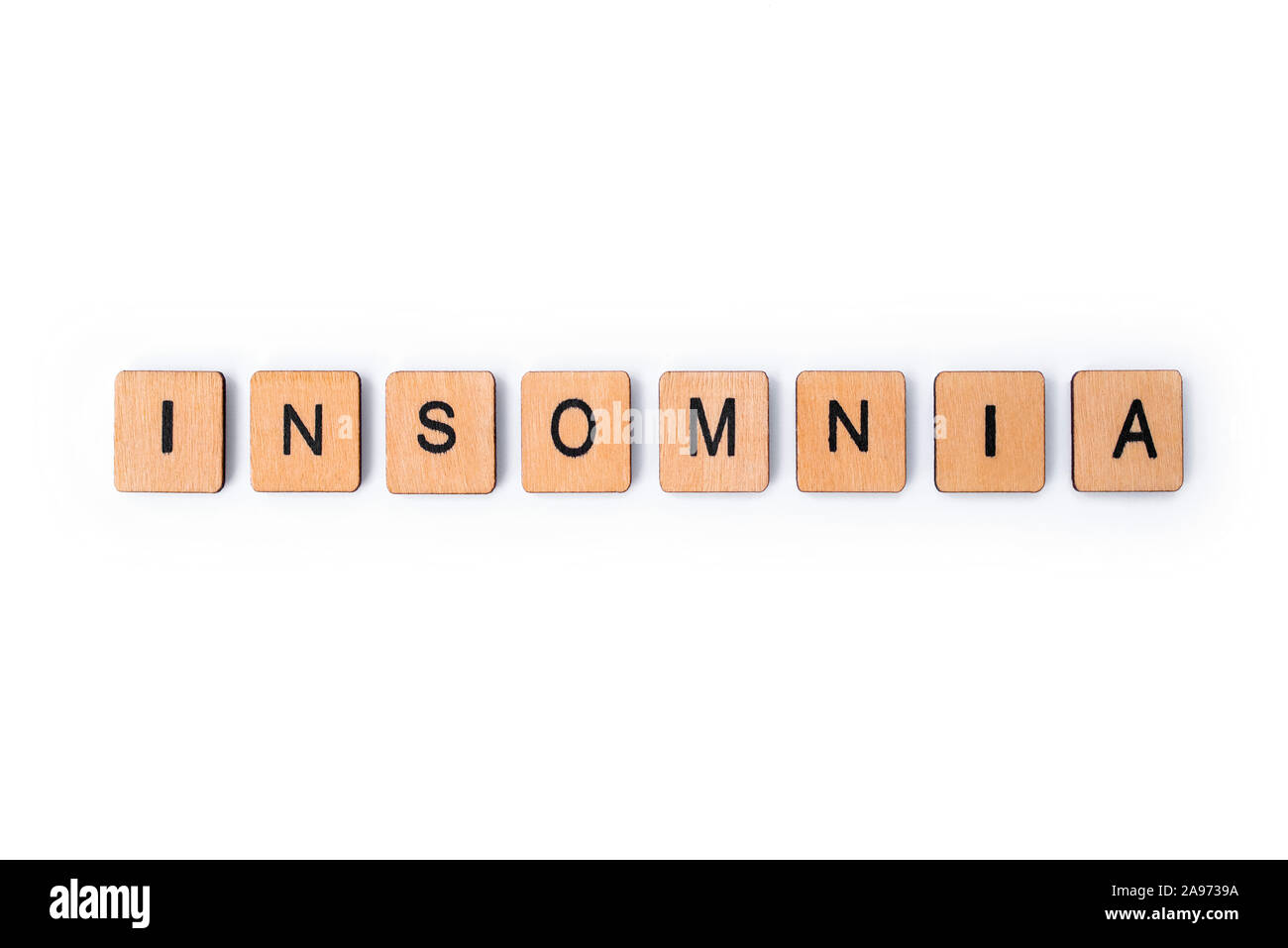 The word INSOMNIA, spelt with wooden letter tiles over a white ...