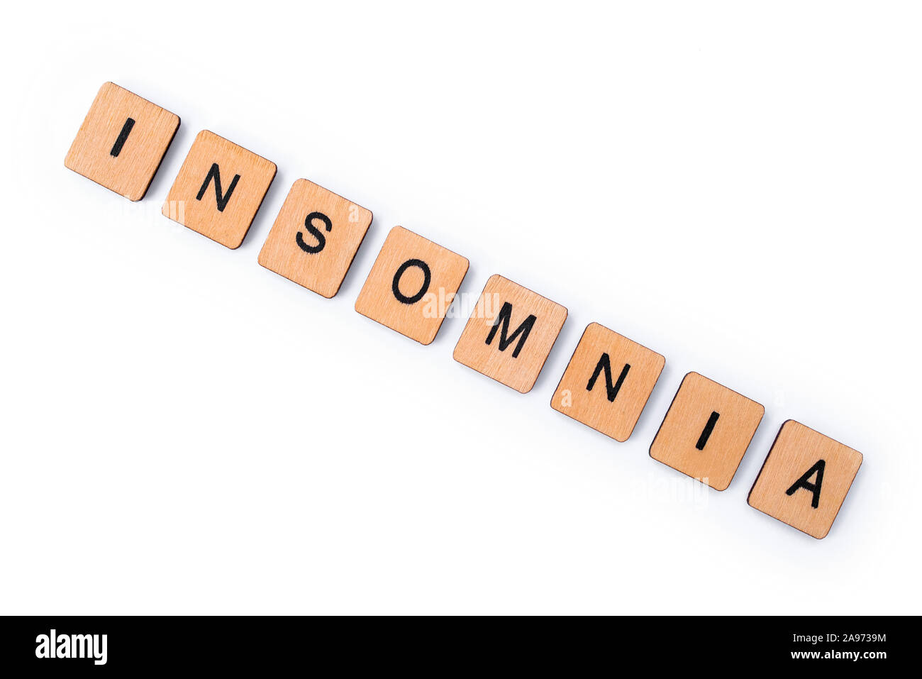 The word INSOMNIA, spelt with wooden letter tiles over a white ...
