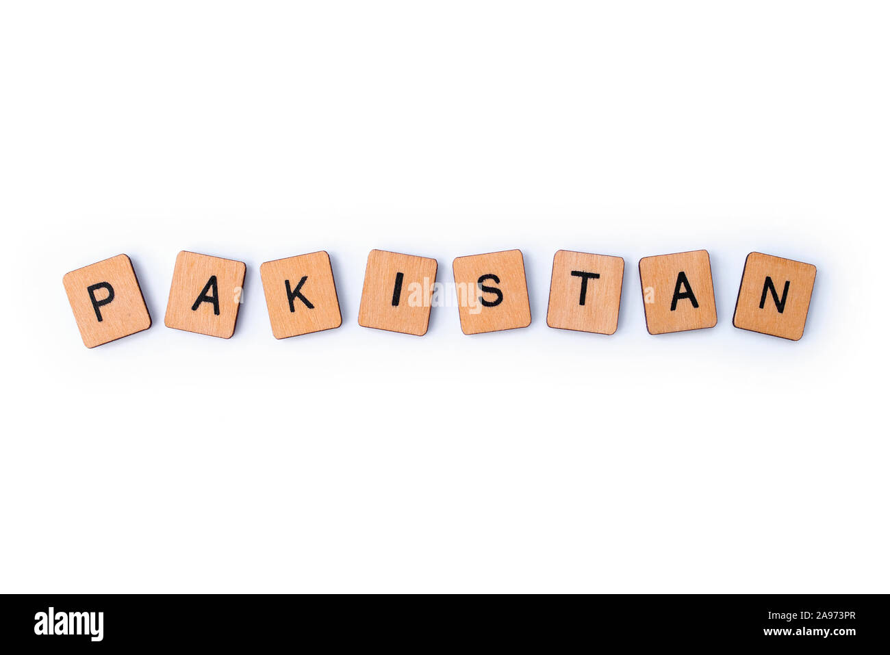 The word PAKISTAN, spelt with wooden letter tiles over a white ...