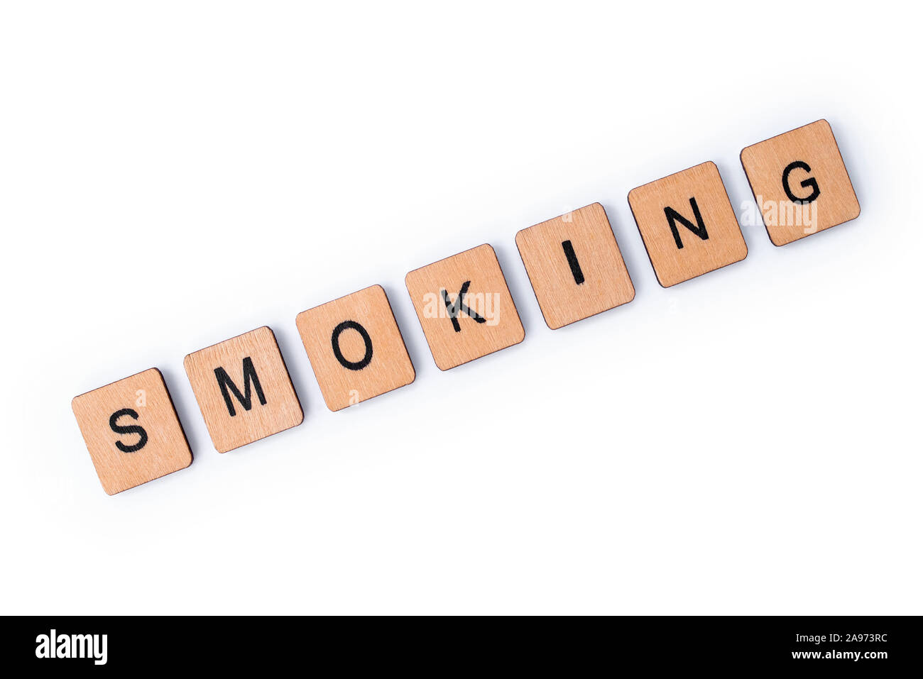 The word SMOKING, spelt with wooden letter tiles over a white ...