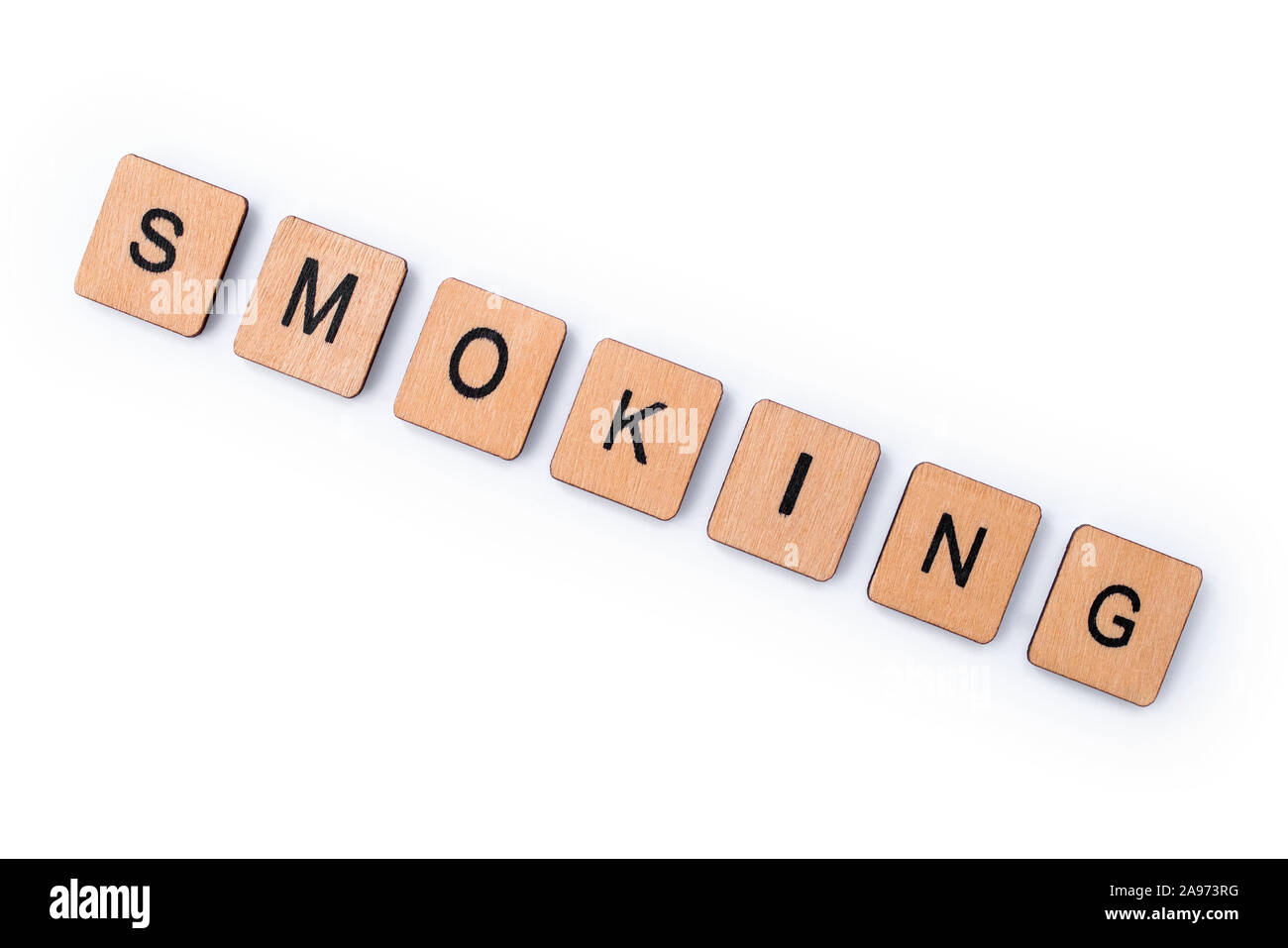 The word SMOKING, spelt with wooden letter tiles over a white ...