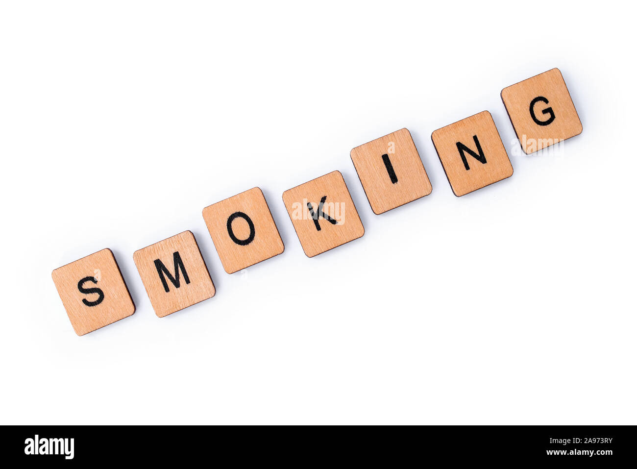The word SMOKING, spelt with wooden letter tiles over a white ...