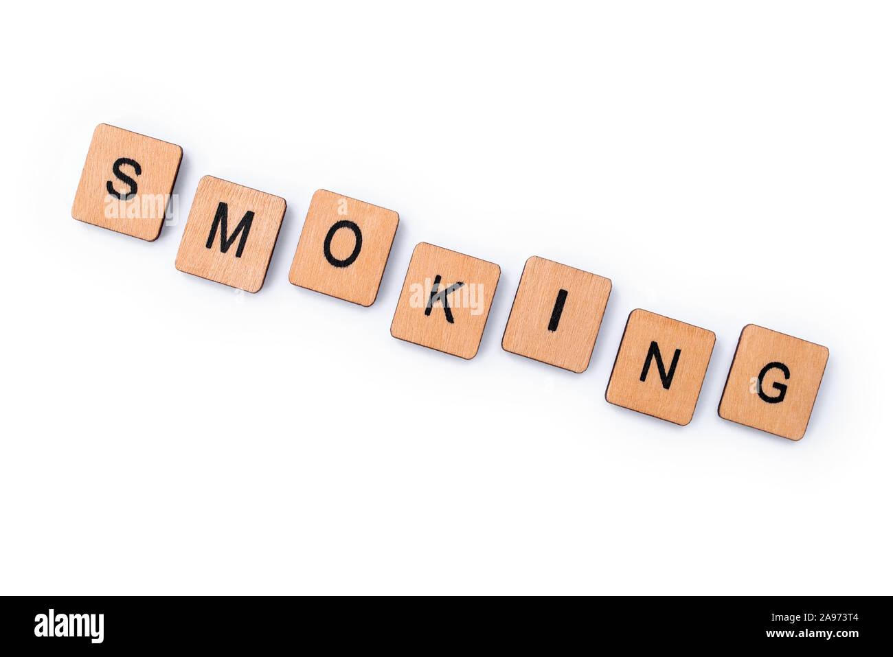 The word SMOKING, spelt with wooden letter tiles over a white ...