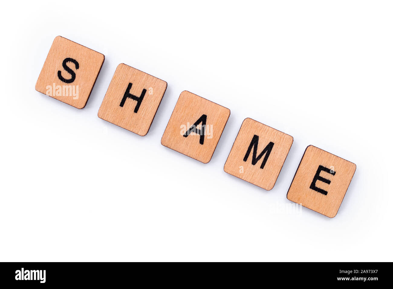 The word SHAME, spelt with wooden letter tiles over a white background ...