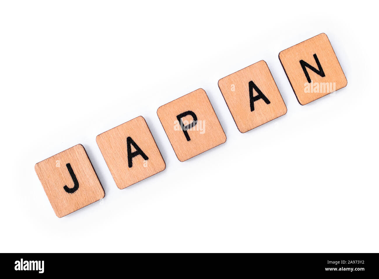 The word JAPAN, spelt with wooden letter tiles, over a white background ...