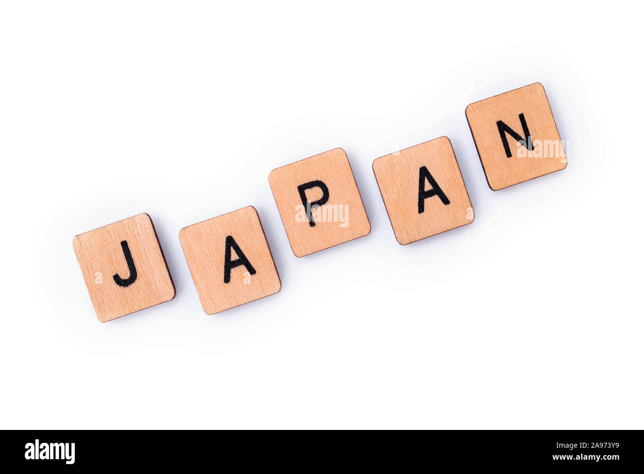 The word JAPAN, spelt with wooden letter tiles, over a white background ...