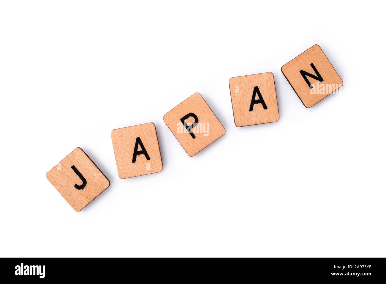 The word JAPAN, spelt with wooden letter tiles, over a white background ...