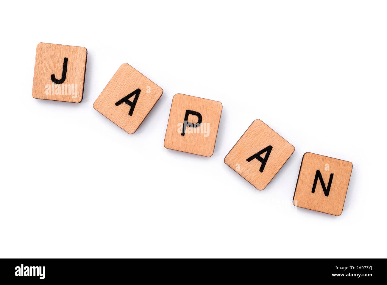 The word JAPAN, spelt with wooden letter tiles, over a white background ...