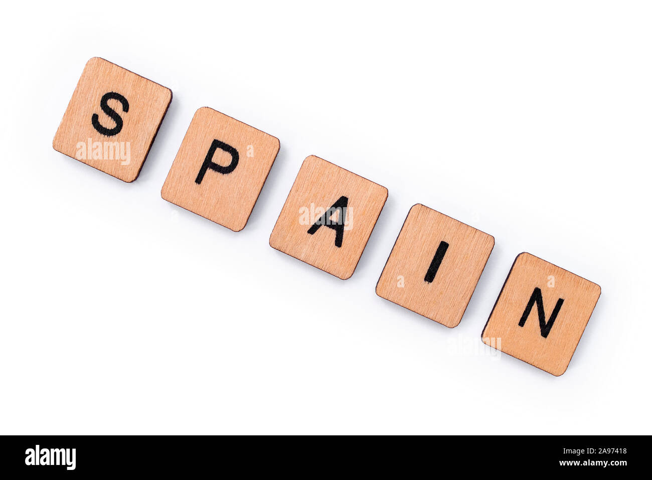 The word SPAIN, spelt with wooden letter tiles, over a white background ...