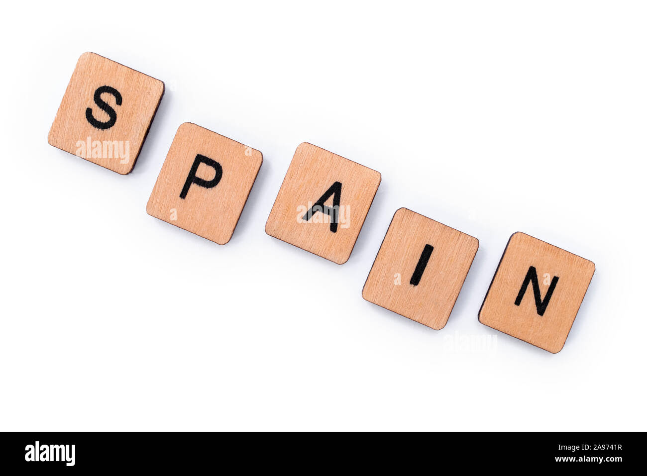 The word SPAIN, spelt with wooden letter tiles, over a white background ...