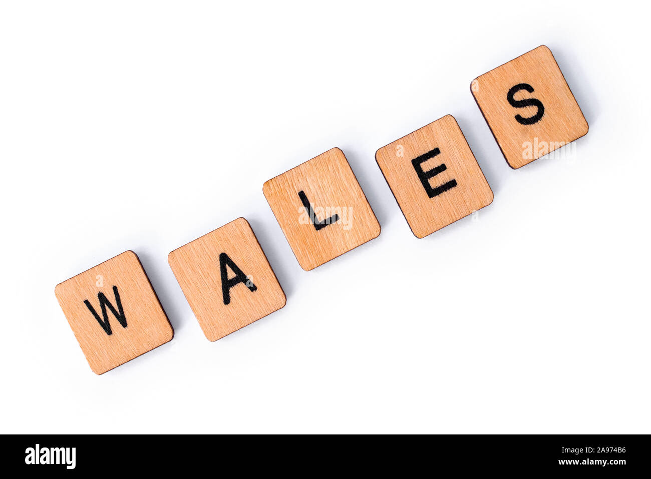 The word WALES, spelt with wooden letter tiles, over a plain white ...