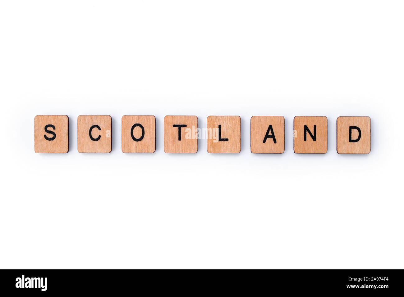 The word SCOTLAND, spelt with wooden letter tiles, over a plain white ...