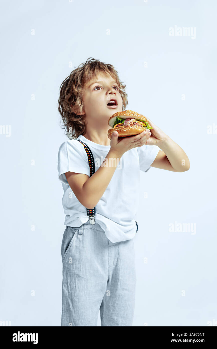 Pretty young curly boy in casual clothes on white studio background ...