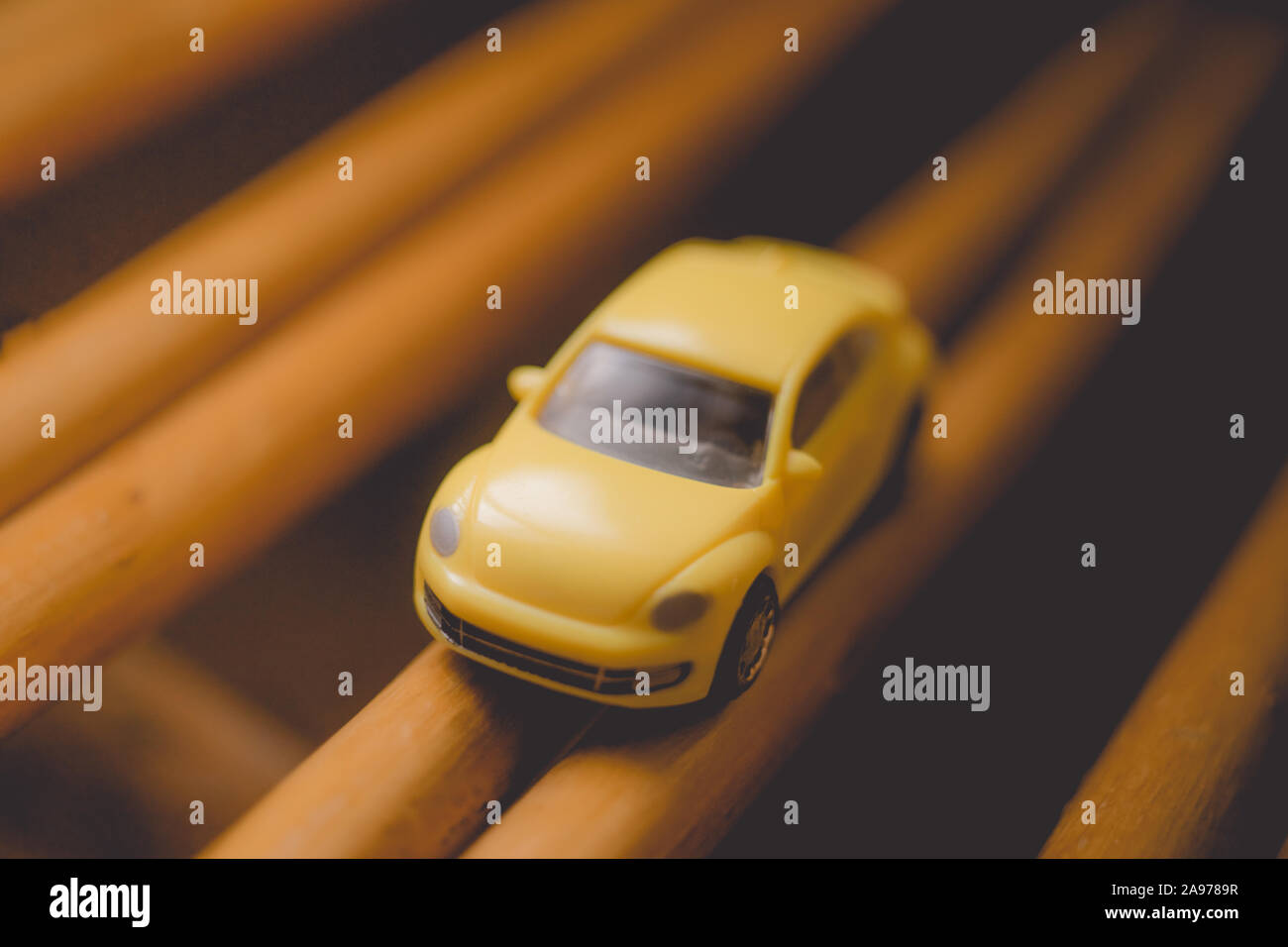 Small yellow toy car on the brown road Stock Photo - Alamy